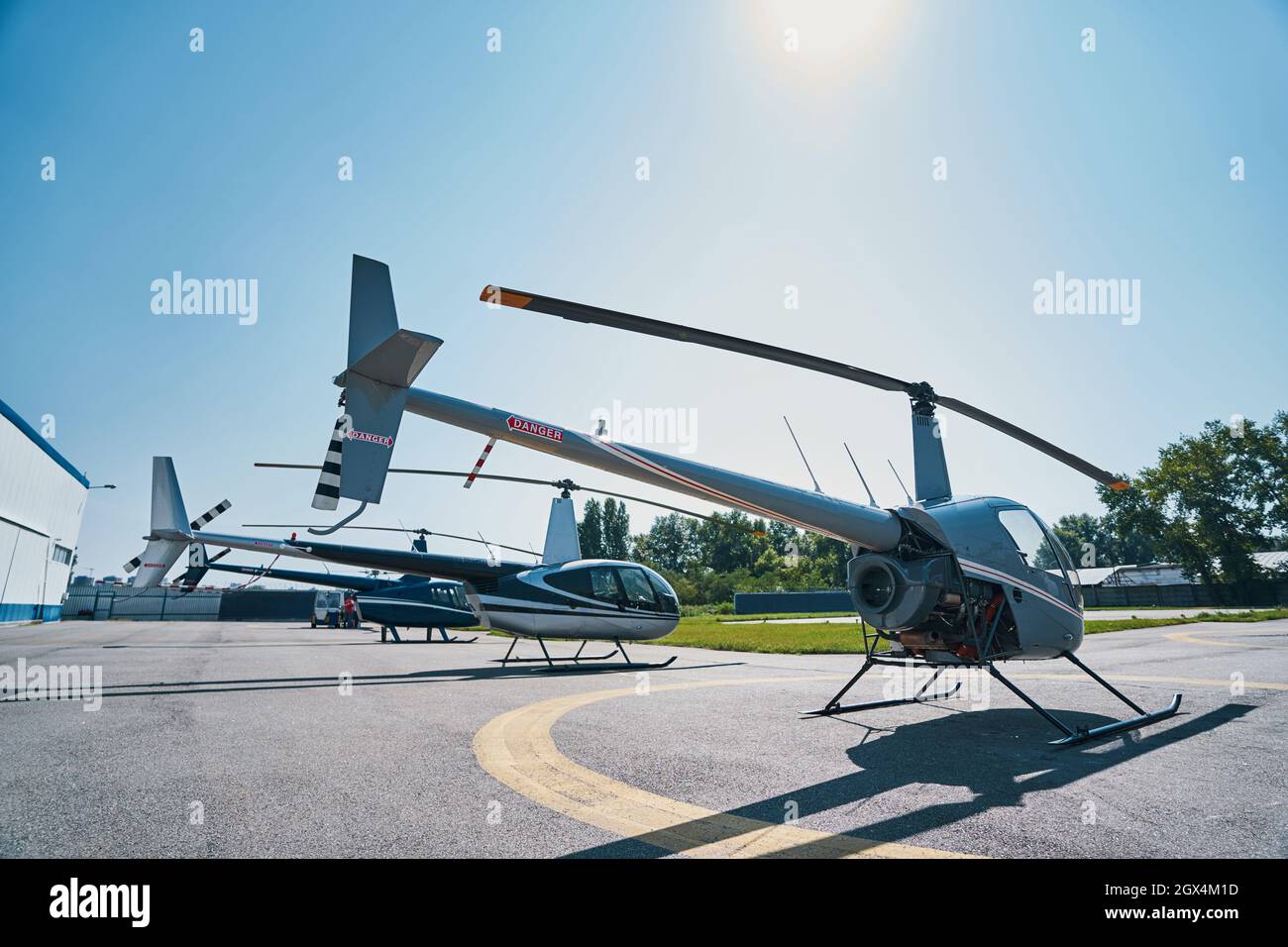 Three helicopters with danger markings on rear rotors at heliport Stock ...