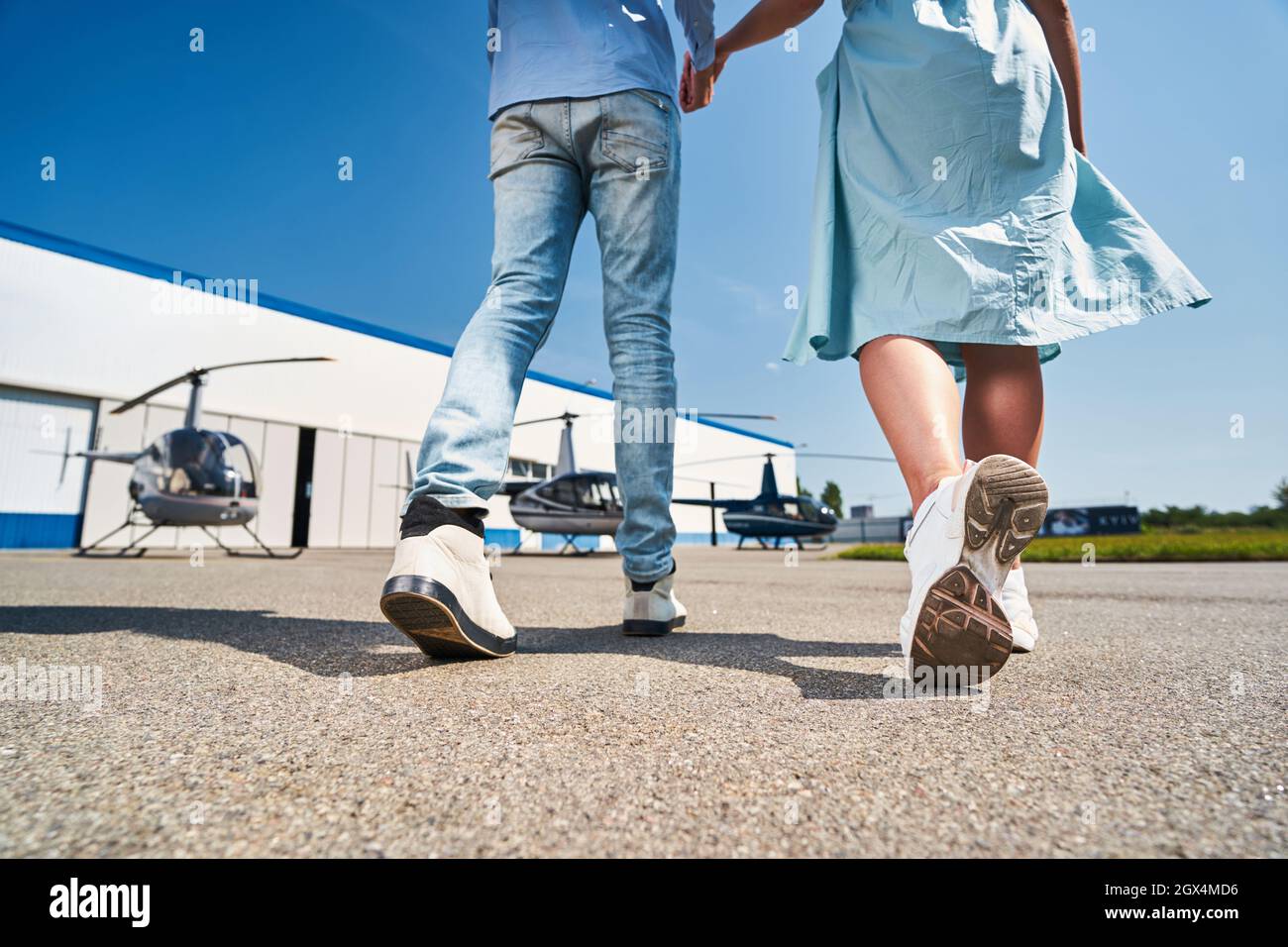 Two adult Caucasian people approaching private helicopters Stock Photo ...