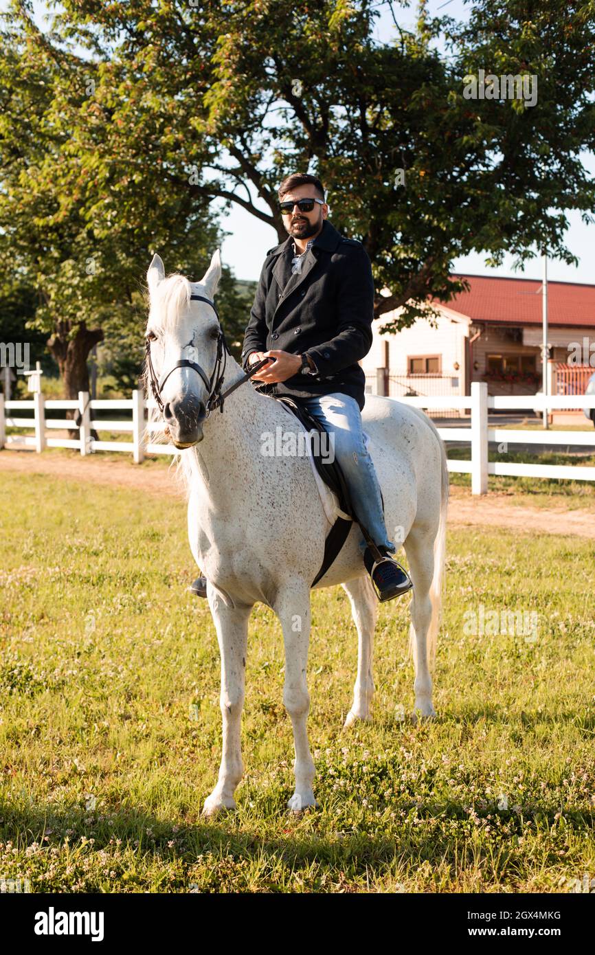 The young man is riding a horse on a farm Stock Photo - Alamy