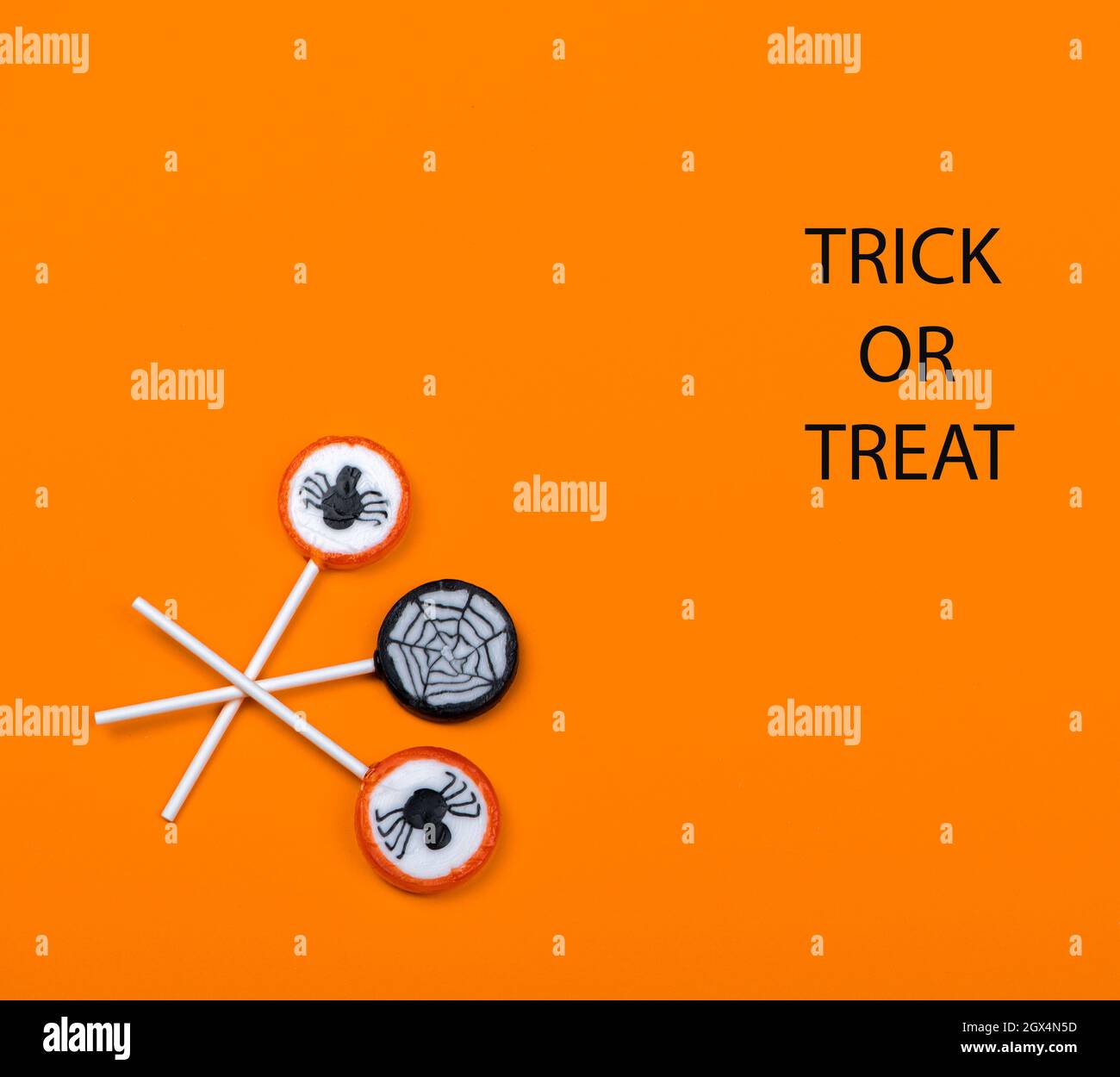 Halloween candy with black spiders and cobweb on orange color ...