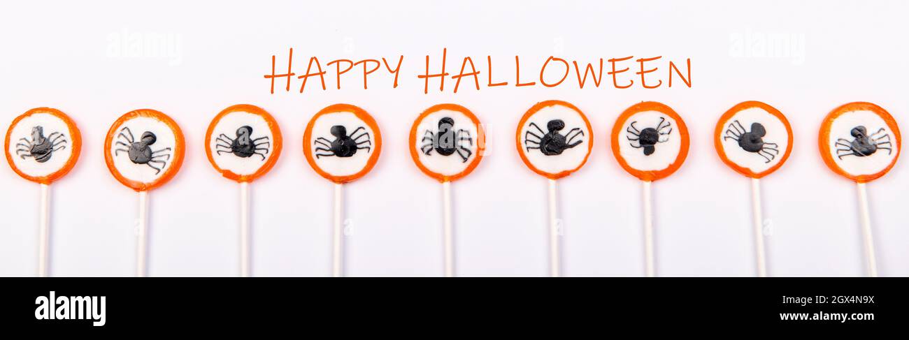 Row of candy with black spiders and words happy halloween isolated on ...