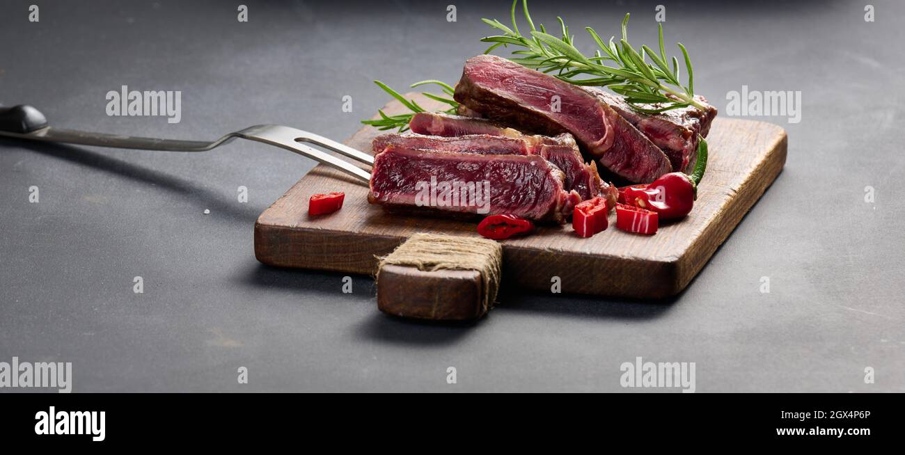 roasted piece of beef ribeye cut into pieces on a vintage brown ...