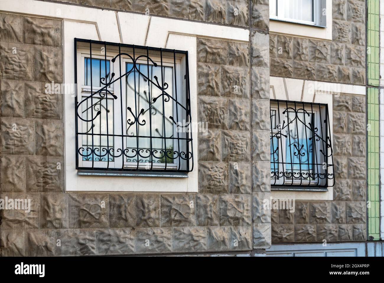 Wrought iron patterned grilles are installed outside on the first floor ...