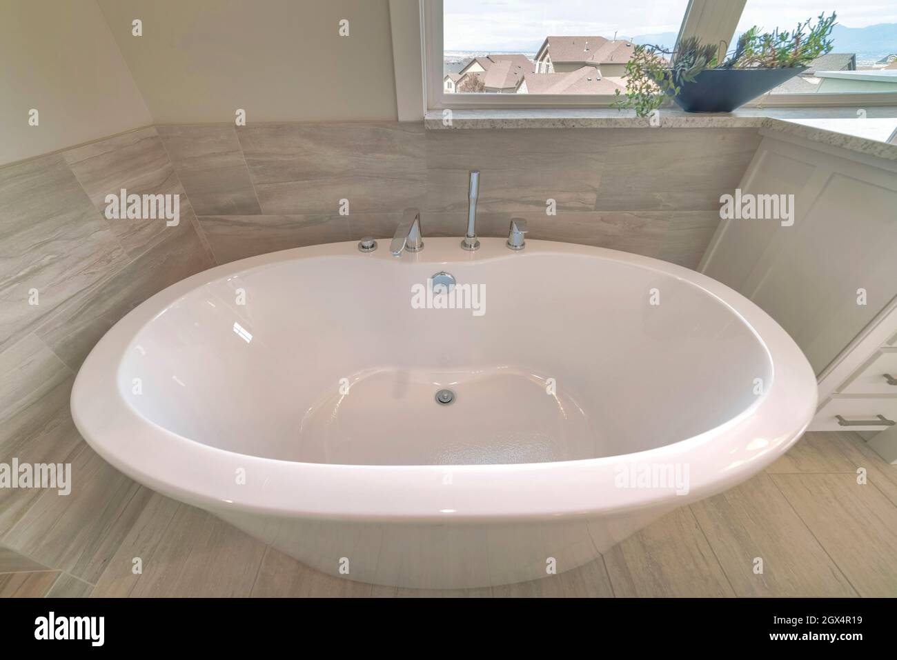 Part of a modern bathroom with oval bath and shower Stock Photo - Alamy