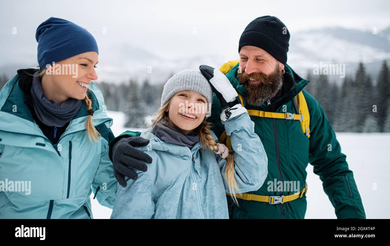 Happy family with small daughter walking outdoors in winter nature ...