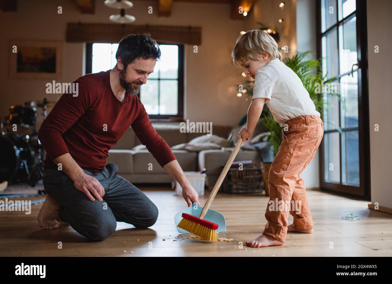 Father with small son sweeping at home, daily chores concept Stock ...