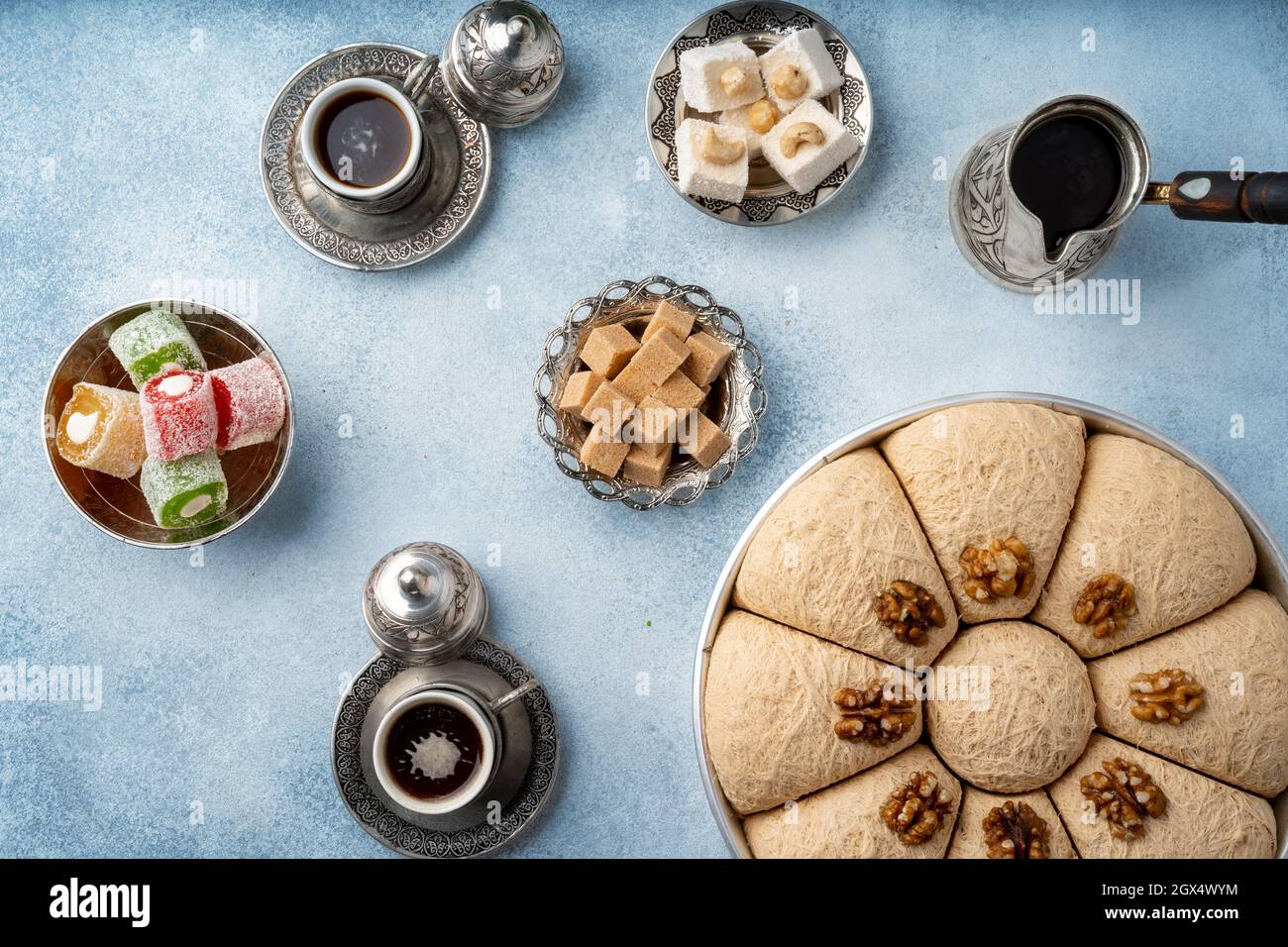 Top view of Turkish sweets and turkish coffee on light blue background ...