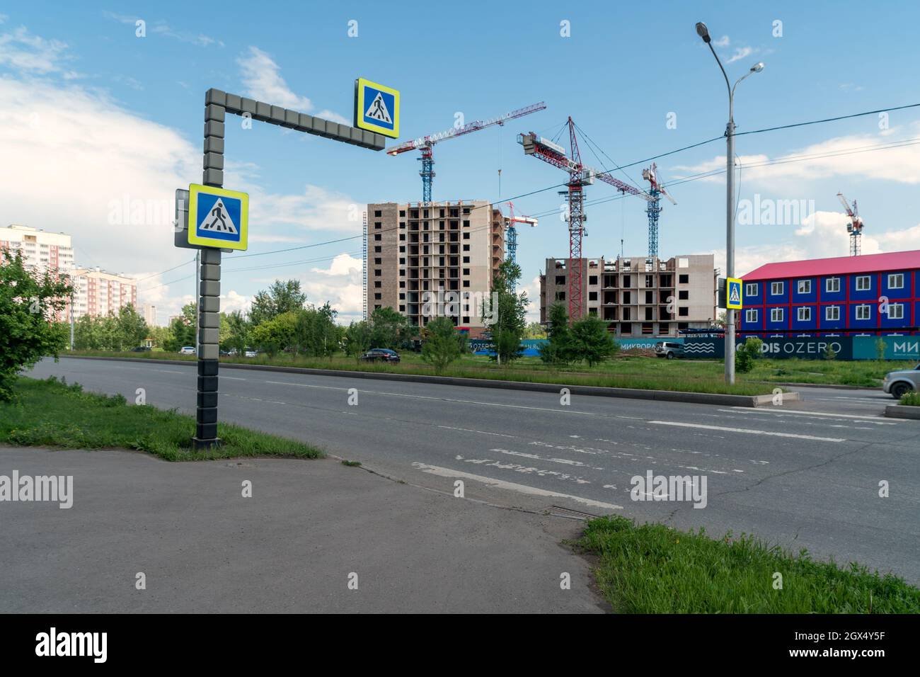 A pedestrian crossing leads across the city road to the construction ...