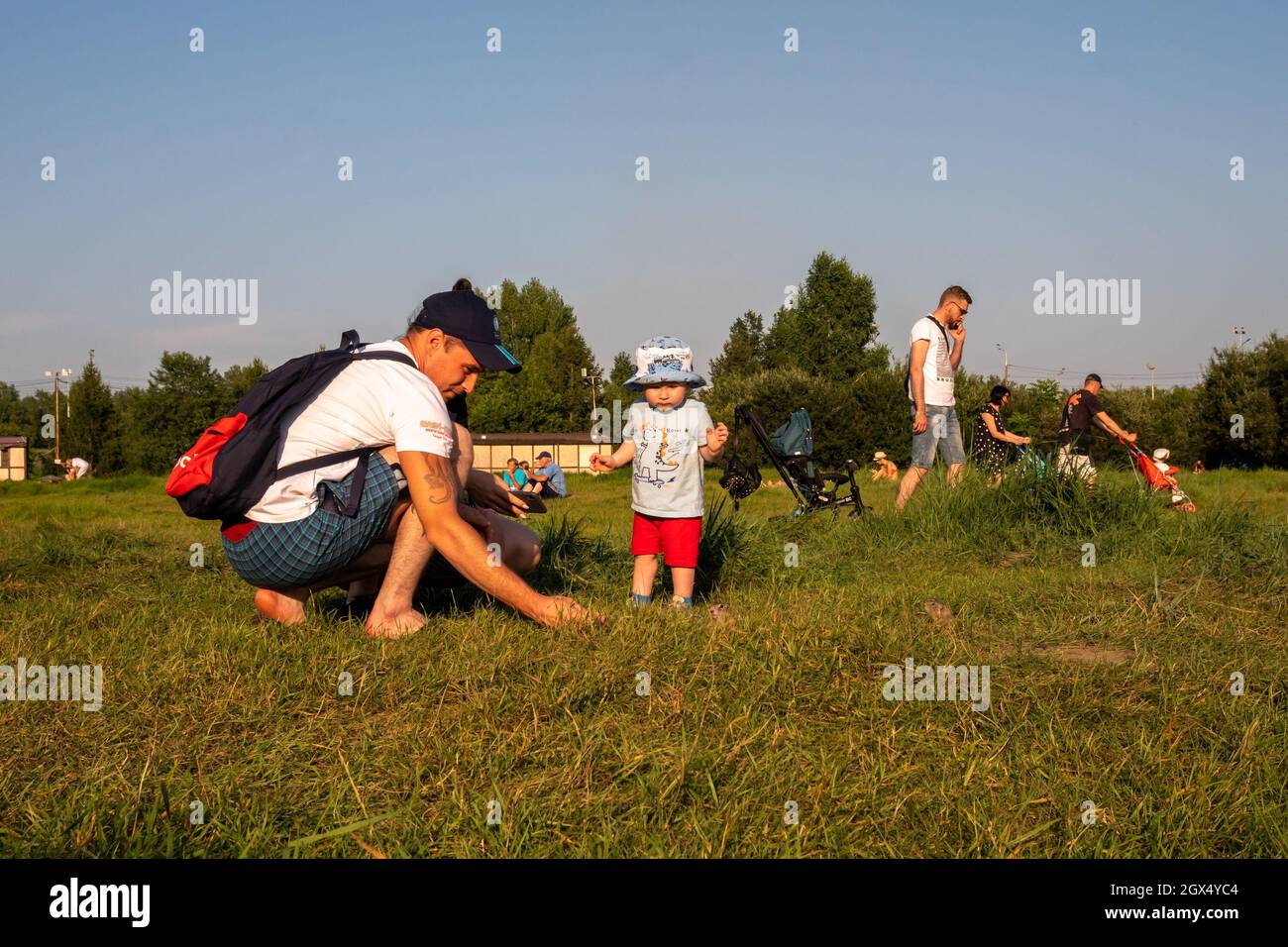 Dad shows his son wild gophers in their natural habitat in a clearing ...