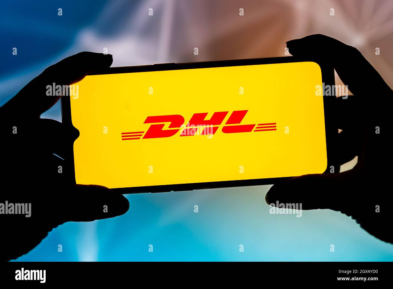In this photo illustration a DHL logo seen displayed on a smartphone ...