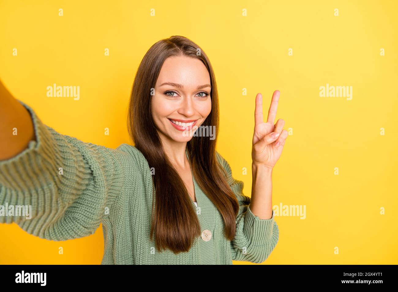 Photo portrait of woman showing v-sign taking selfie isolated on vivid ...