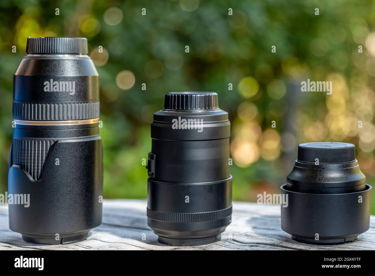 Three reflex camera lenses, on a green background with bokeh lights ...