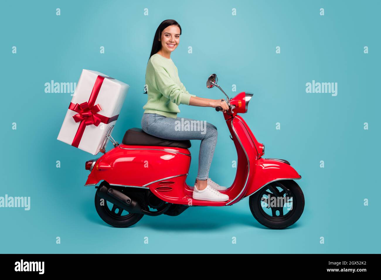 Profile side view of attractive cheerful girl riding moped delivering ...