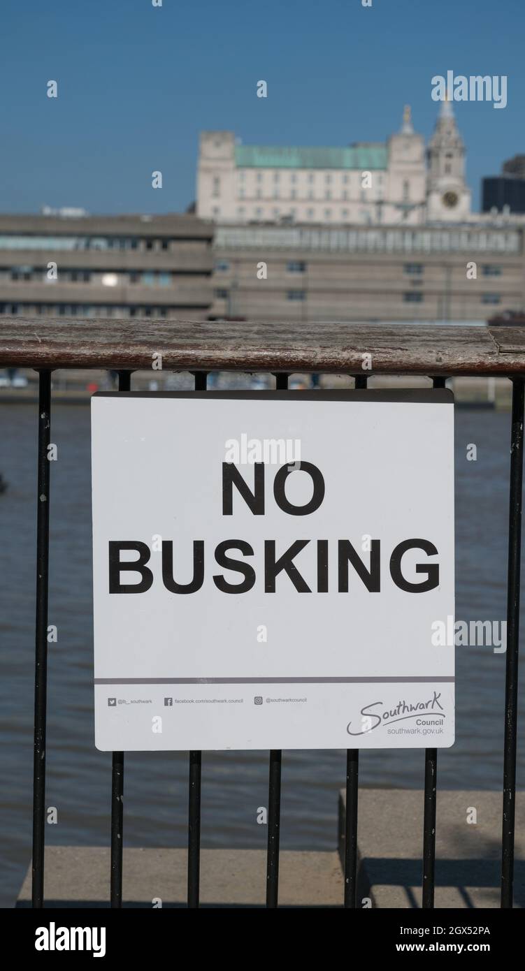 No Busking sign attached to the railings of the River Thames walkway ...