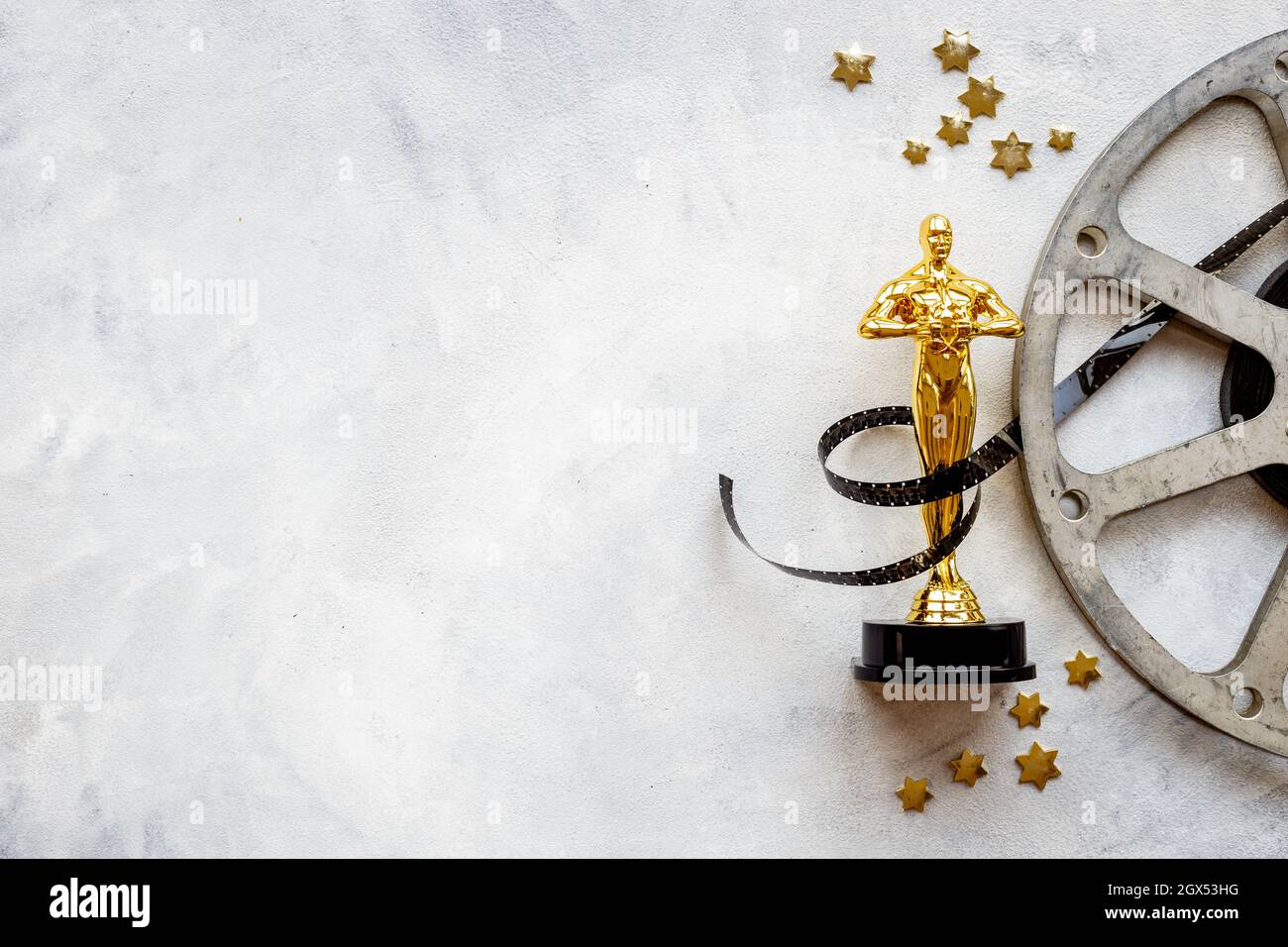Golden film award statue with reel video tape Stock Photo - Alamy