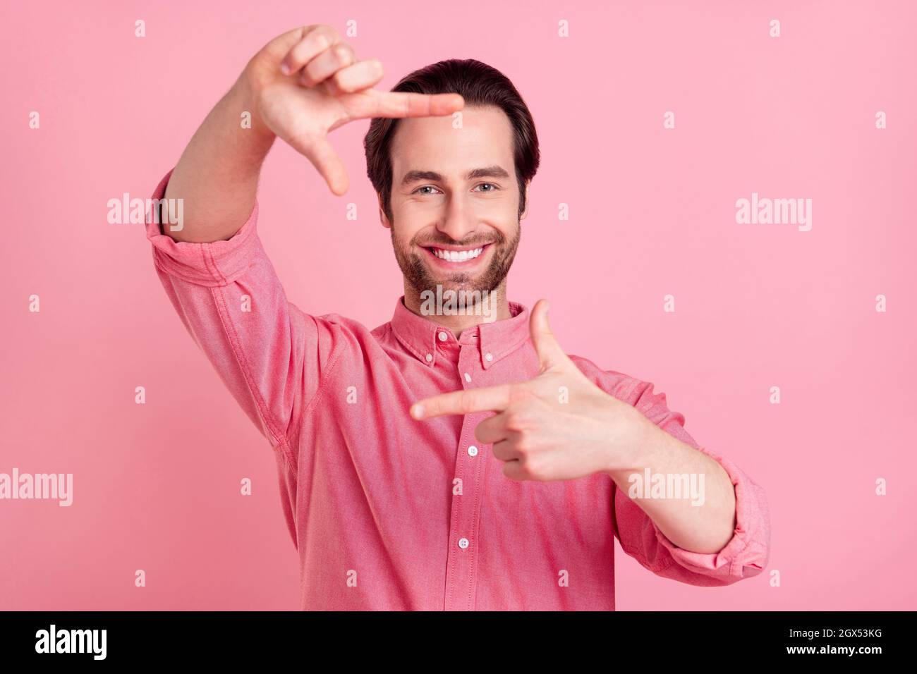 Portrait of attractive cheerful guy showing frame border shooting ...