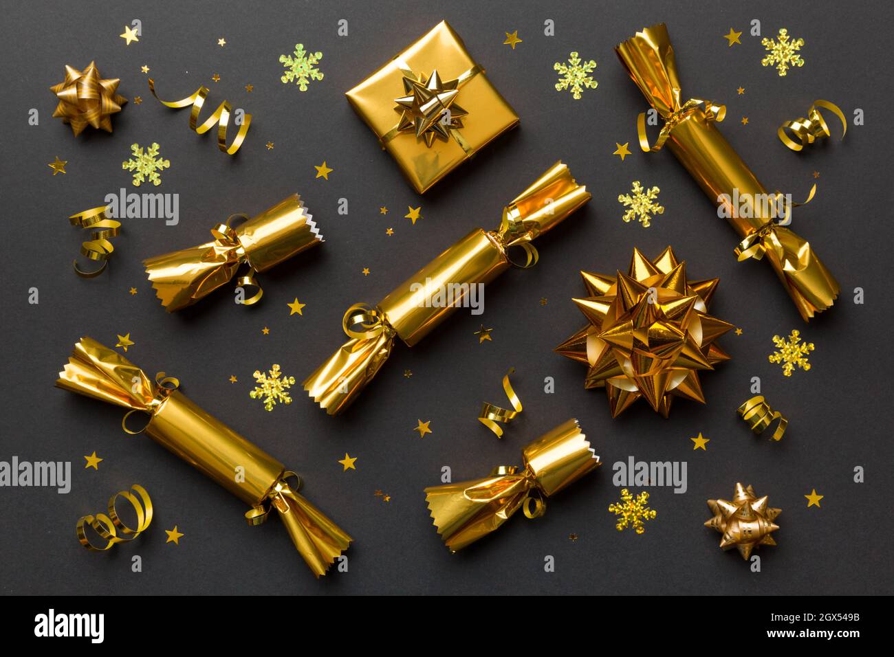 Christmas crackers with shiny confetti on color background, top view ...