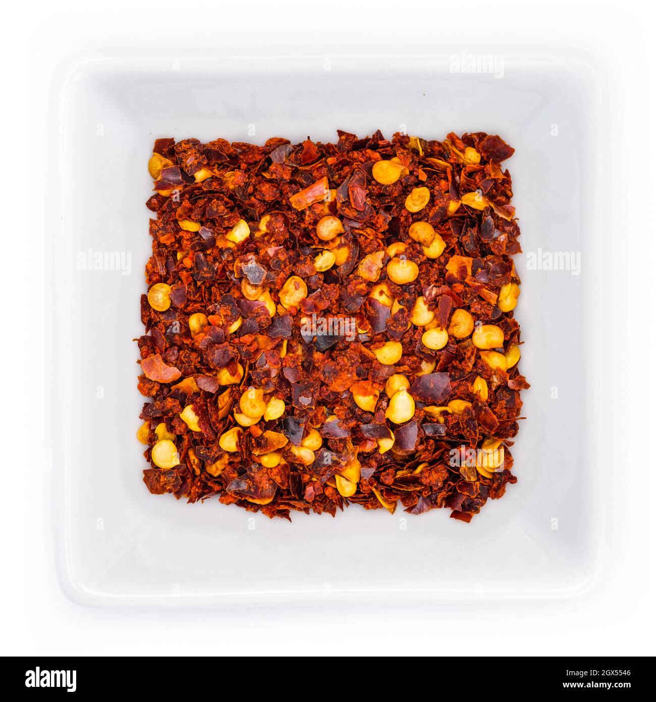 Top view of red chili flakes in a white bowl Stock Photo - Alamy