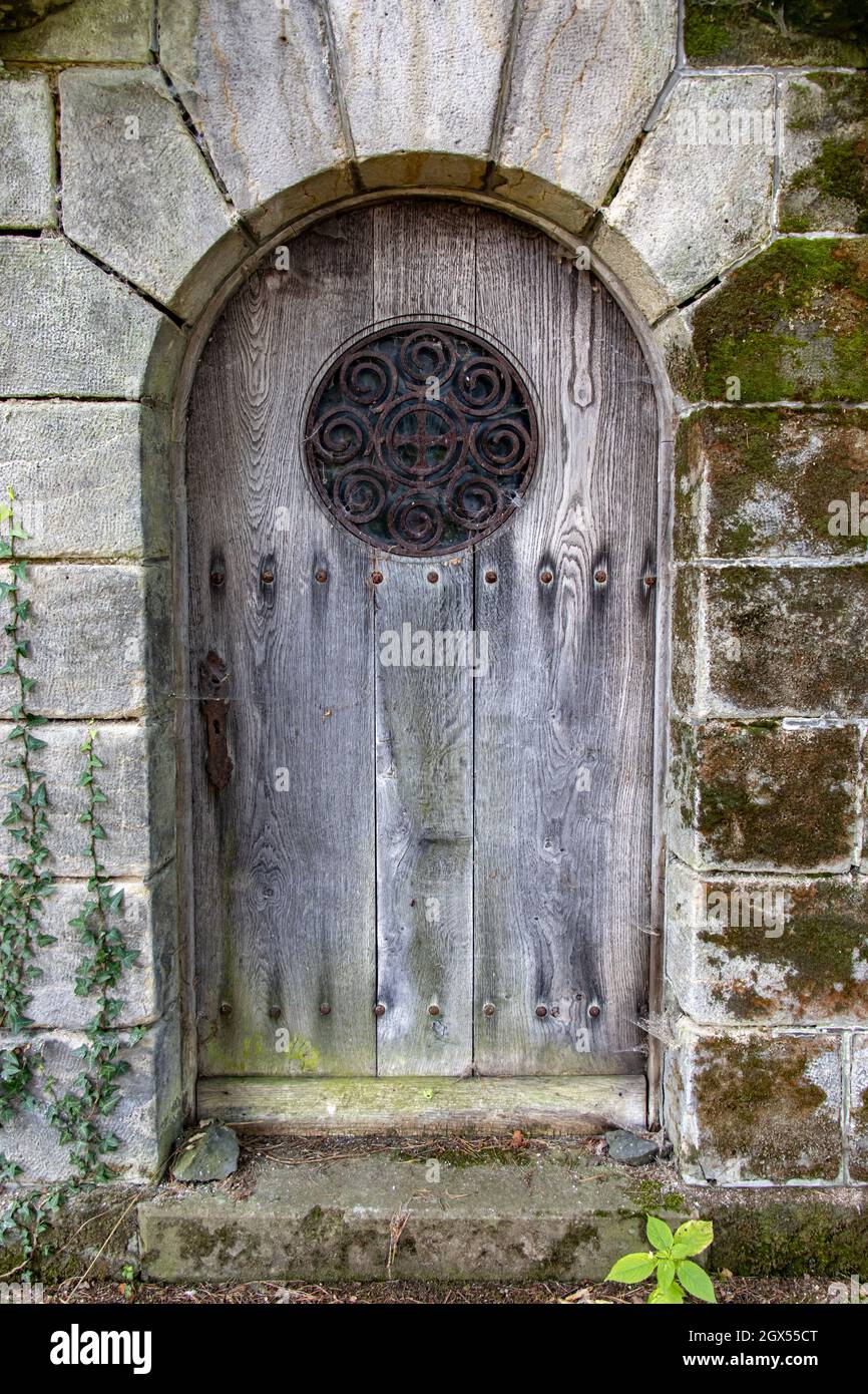 Wooden door with a round window in a historic stone tomb Stock Photo ...