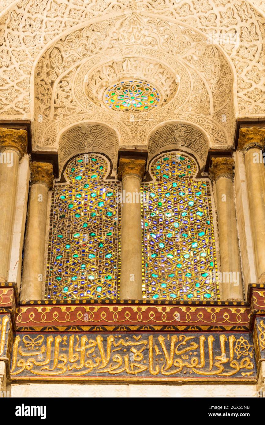 Two adjacent perforated stucco arched windows decorated with colorful ...