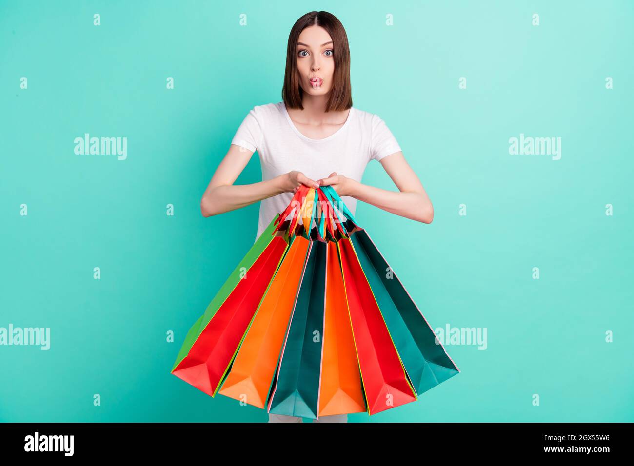 Portrait of attractive amazed girl holding in hands bags pout lips ...