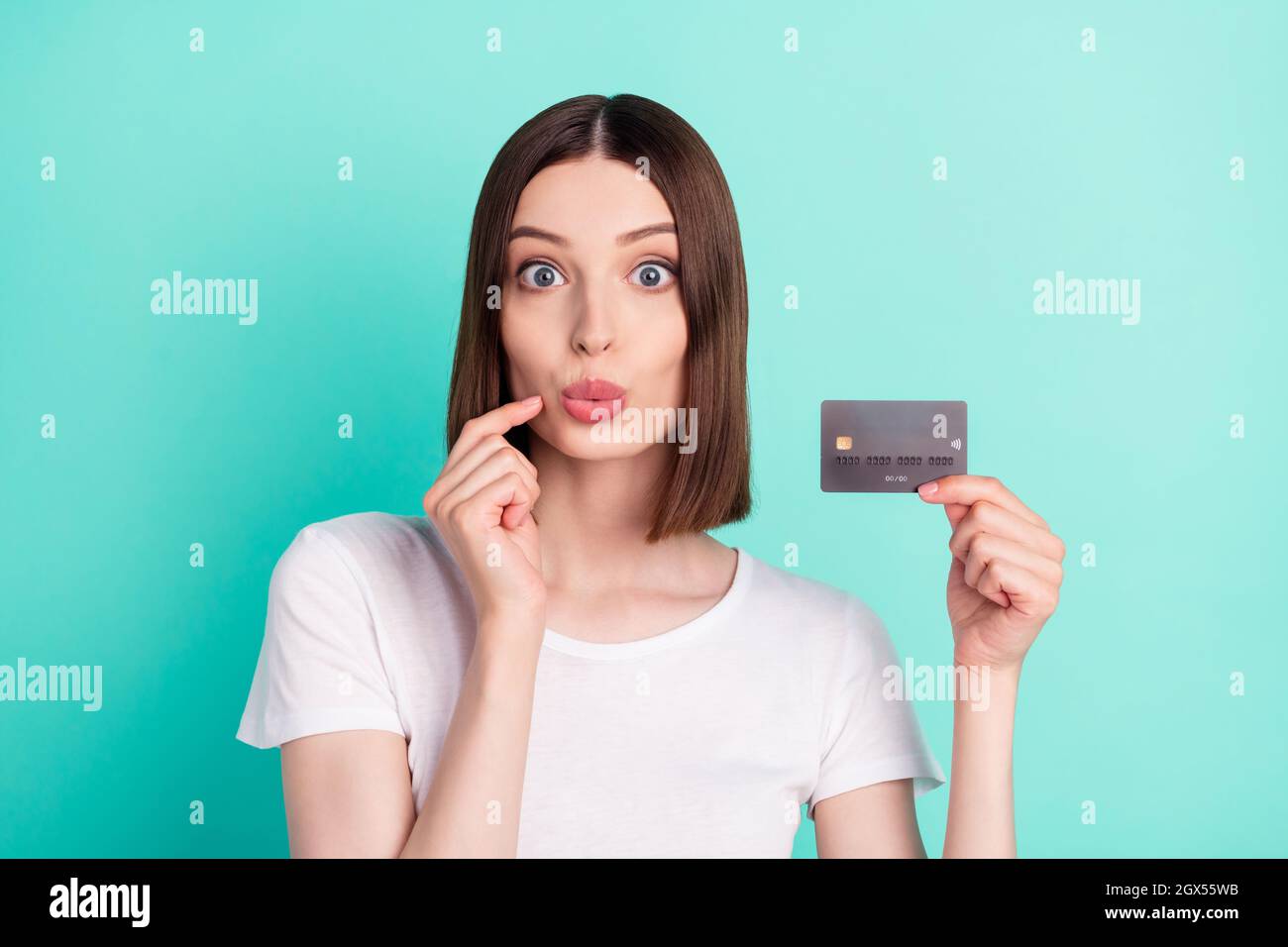 Photo of amazed shocked young woman hold finger face credit card ...