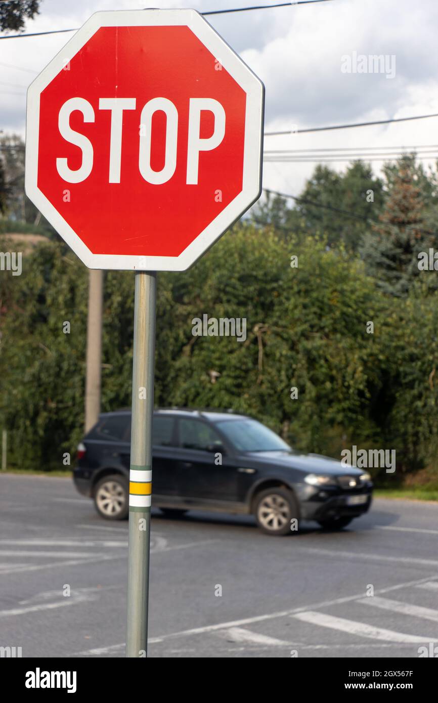 Stop sign in front of a crossing with a rides car Stock Photo - Alamy