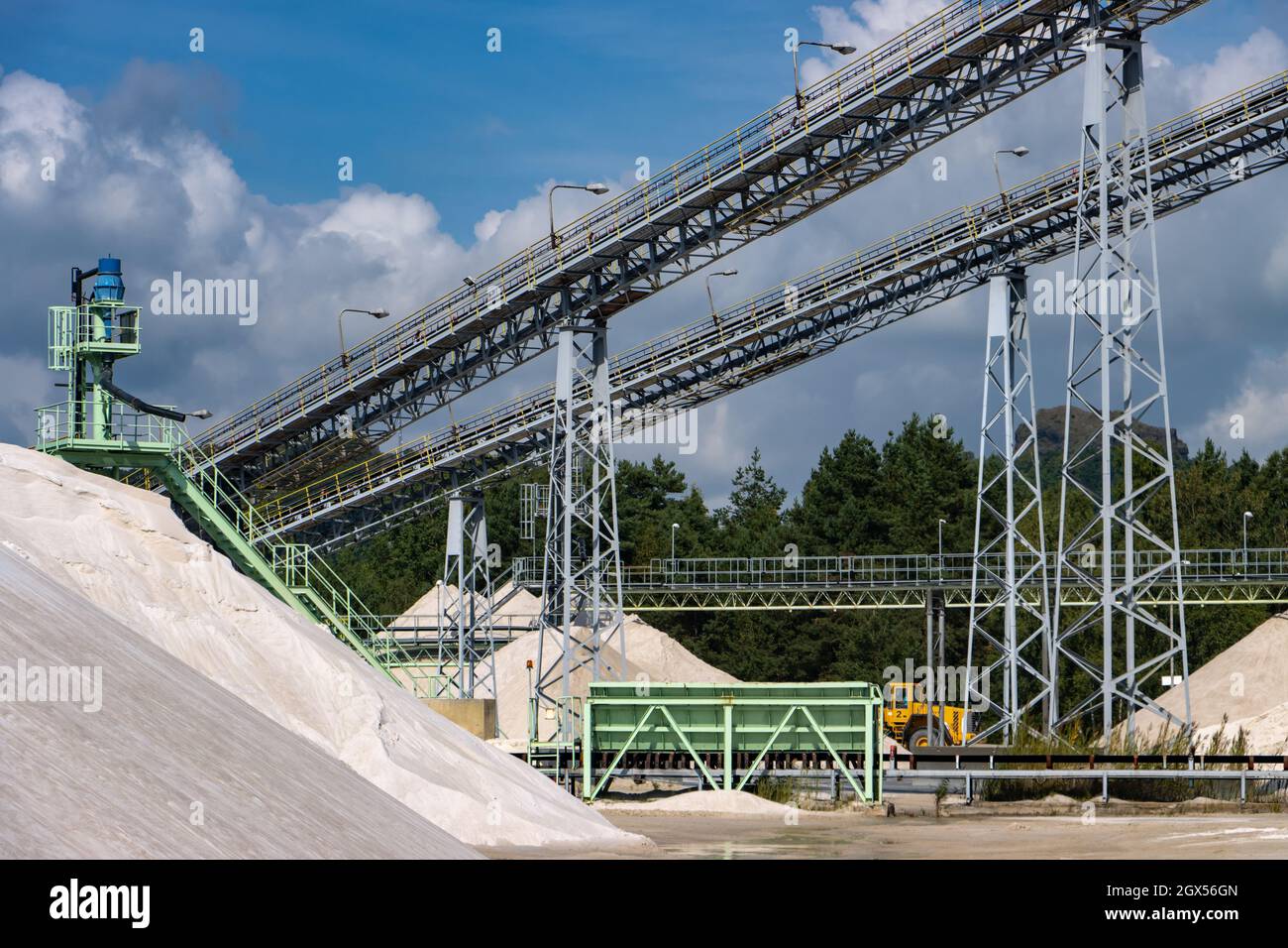 Sand pit with piles of sand and technical equipment incl. conveyor ...
