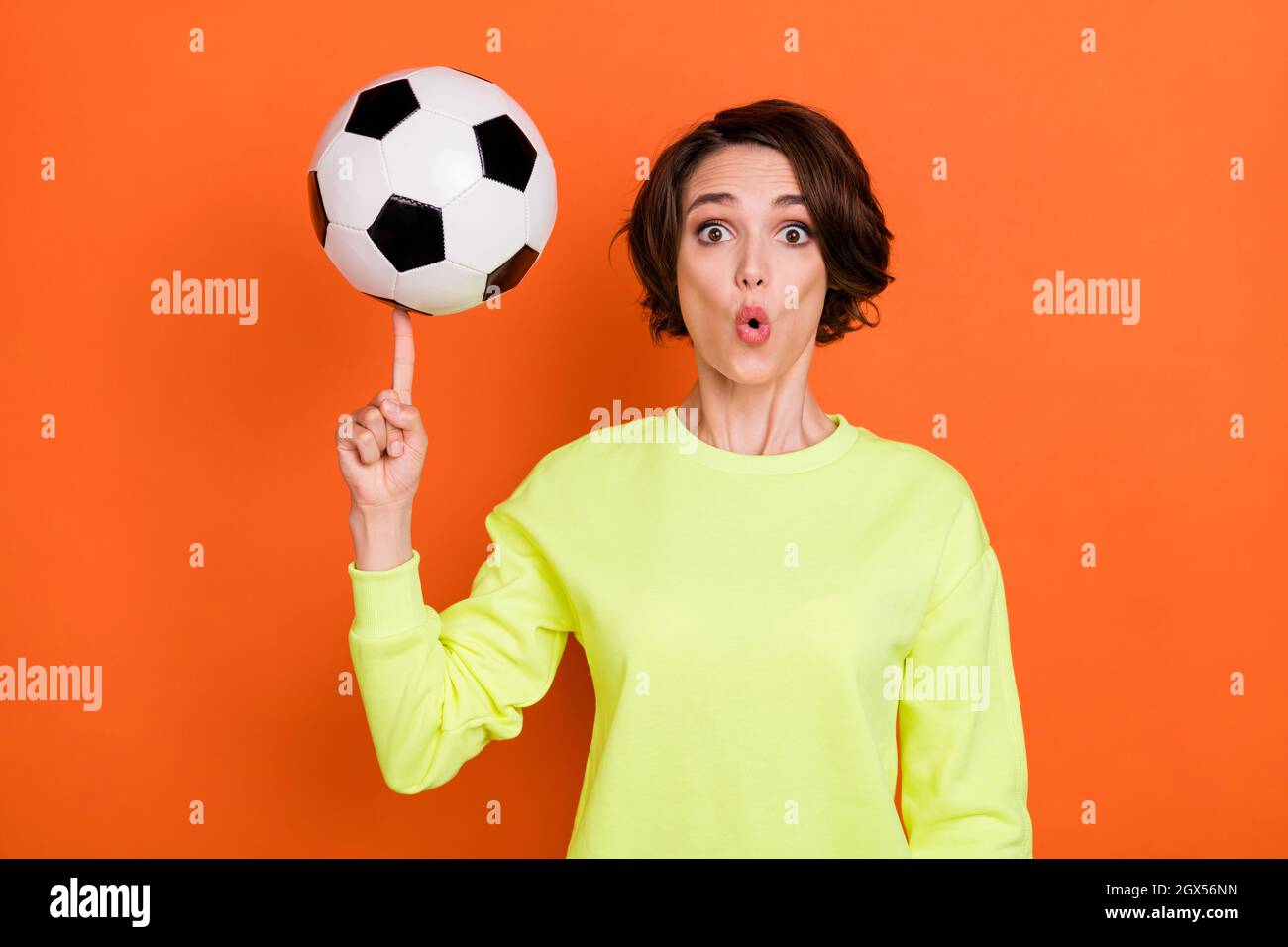 Portrait of attractive cheerful amazed girl spinning ball on forefinger ...