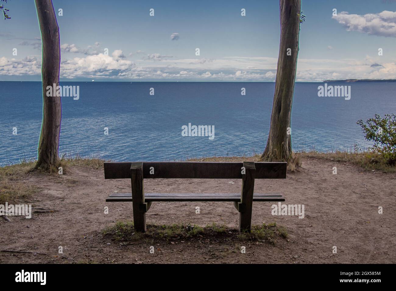 Wooden bench facing the deep blue sea Stock Photo - Alamy