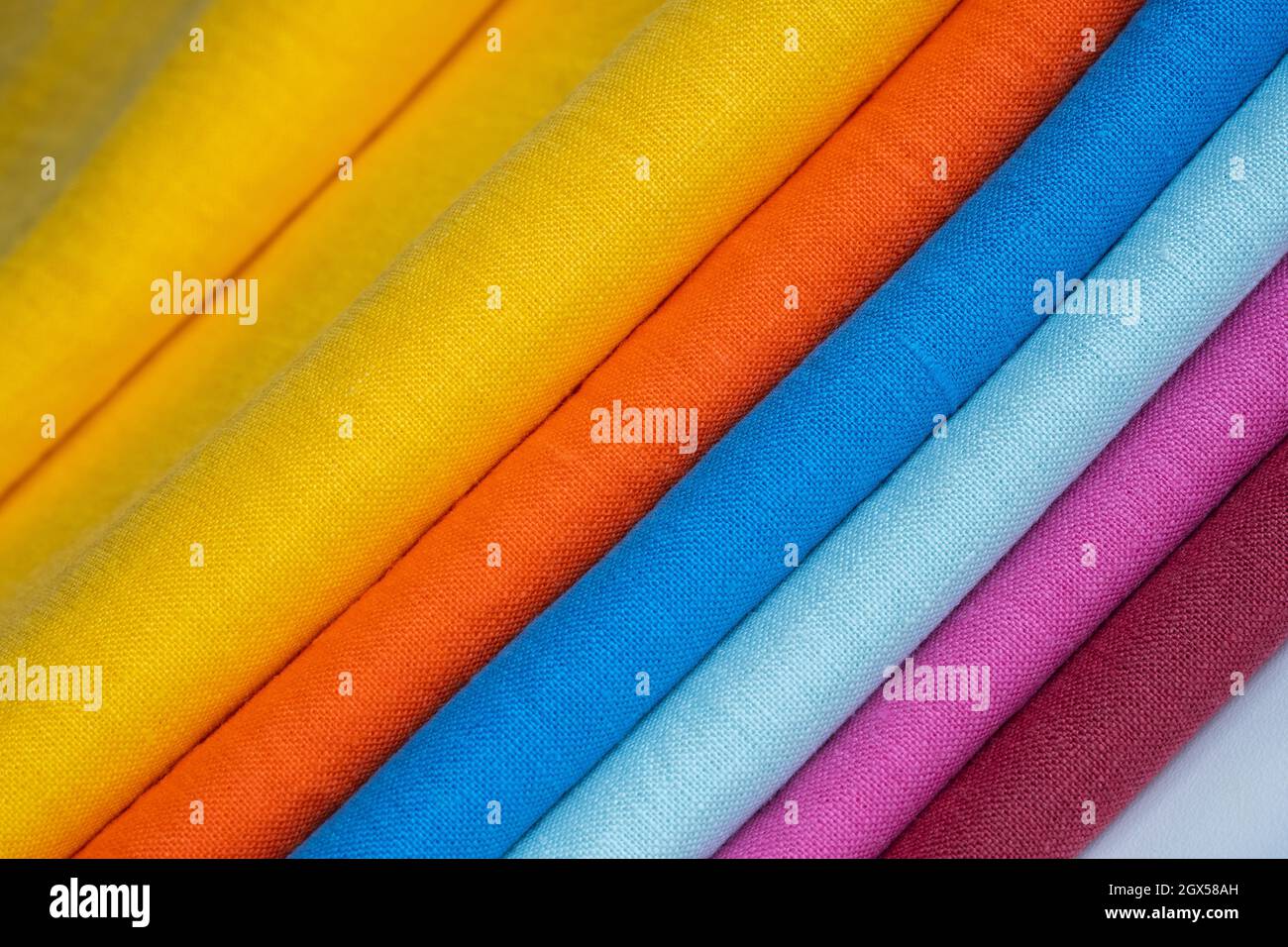 A stack of multi-colored bright linen fabric, close-up. Linen ...