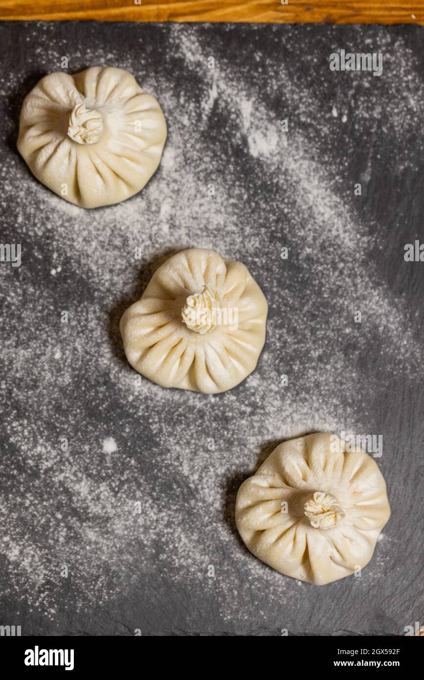 Georgian dumplings Khinkali with meat, on a wooden board with flour ...