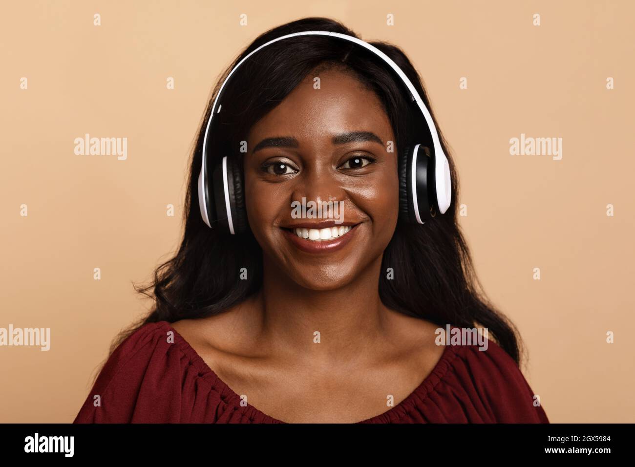 Positive Black Lady Listening To Music Using Wireless Headset Stock