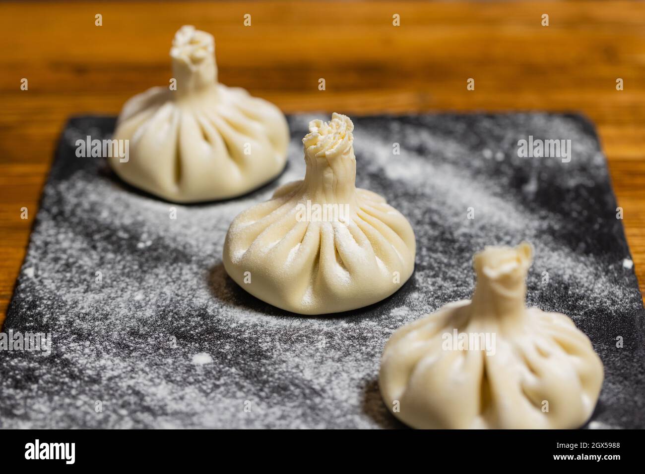Georgian dumplings Khinkali with meat, on a wooden board with flour ...