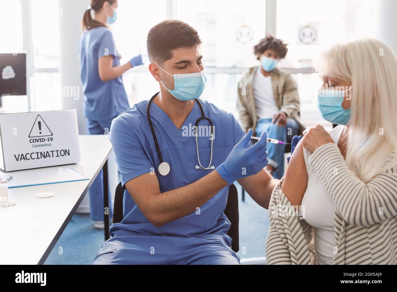 Mature Lady Receiving Vaccine Injection In Arm In Health Center Stock ...