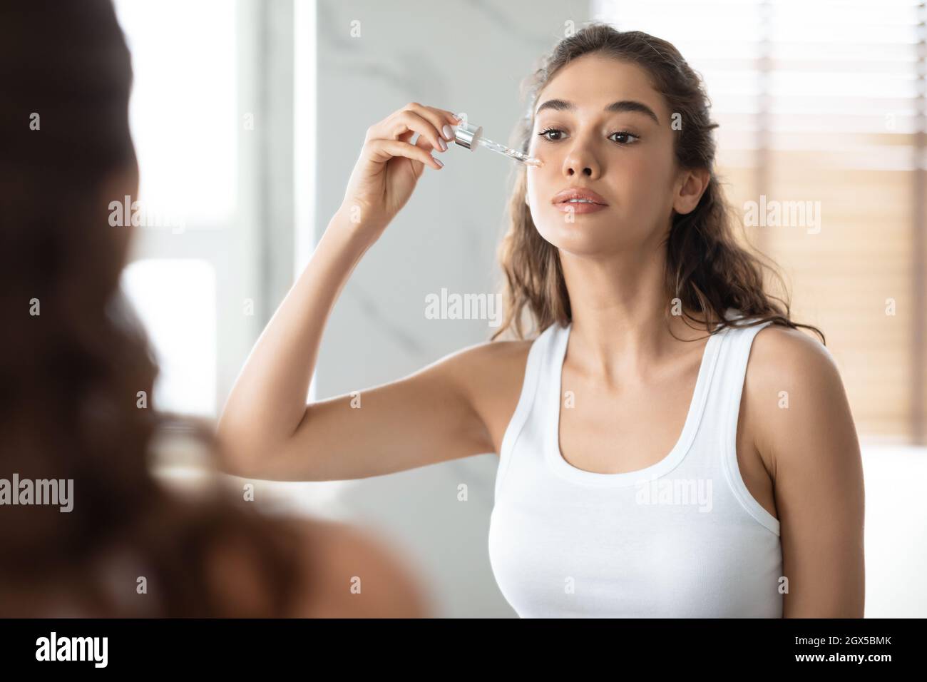Lady Applying Facial Serum With Dropper Caring For Skin Indoor Stock ...