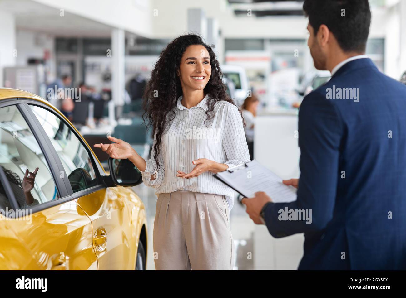 Pretty lady having conversation with sales assistant in showroom Stock ...