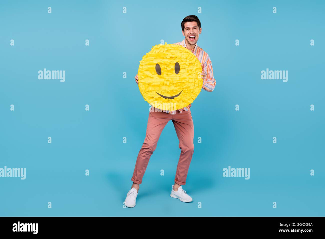 Full length photo of young guy happy positive smile hold paper pinata ...