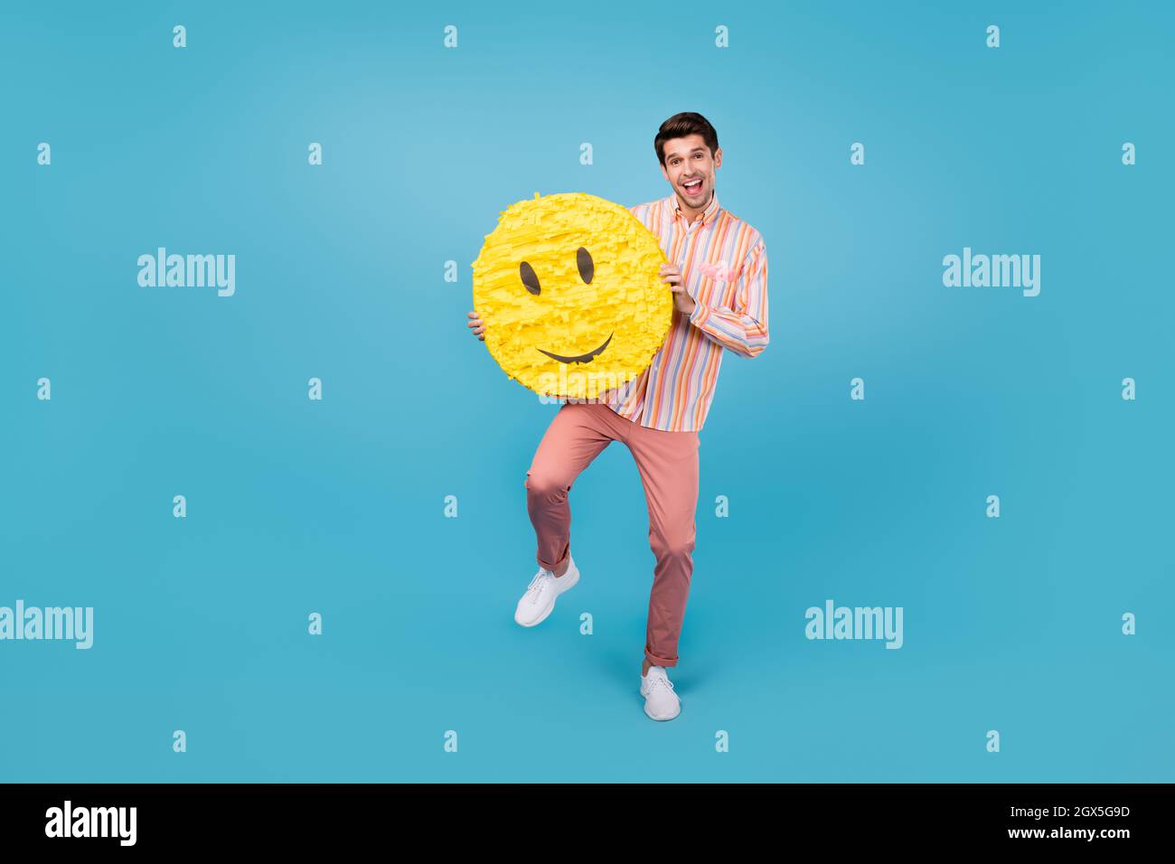 Full body photo of charming happy joyful positive man hold hands emoji ...