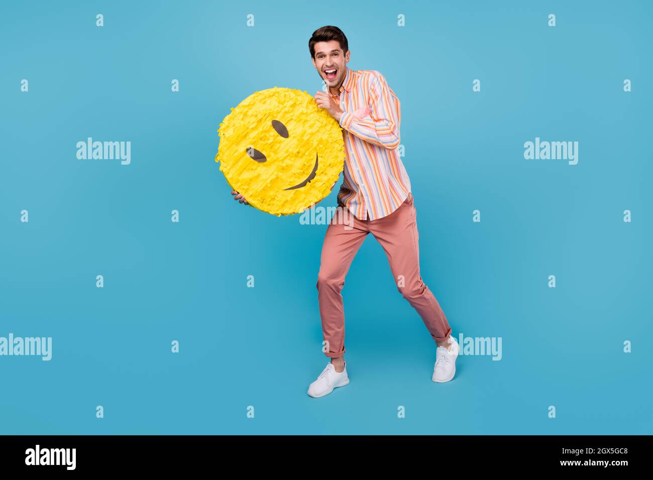 Full size photo of happy positive young man hold hands emoticon smile ...