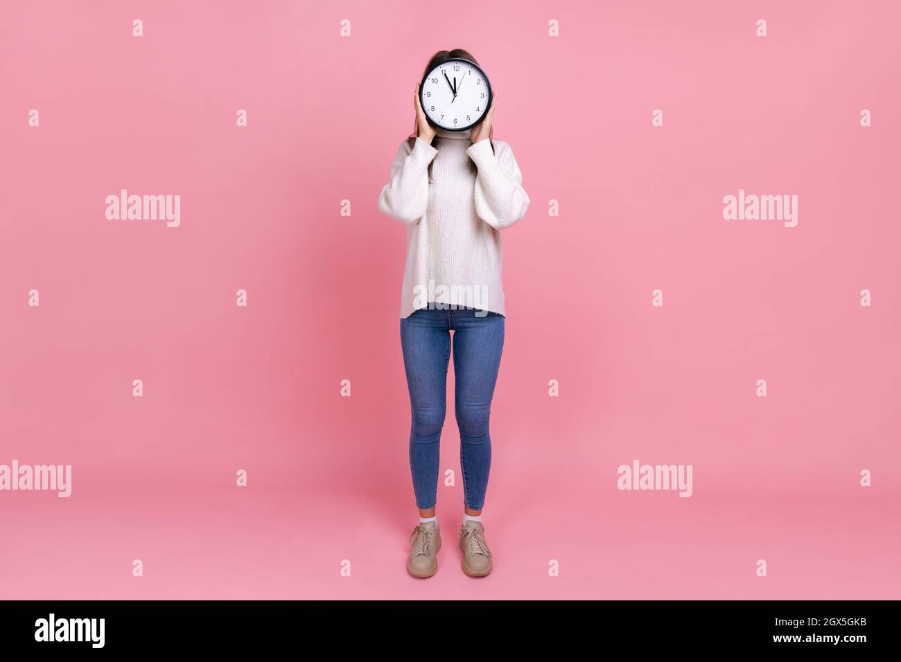 Full length portrait of unknown woman hiding her face behind big wall ...