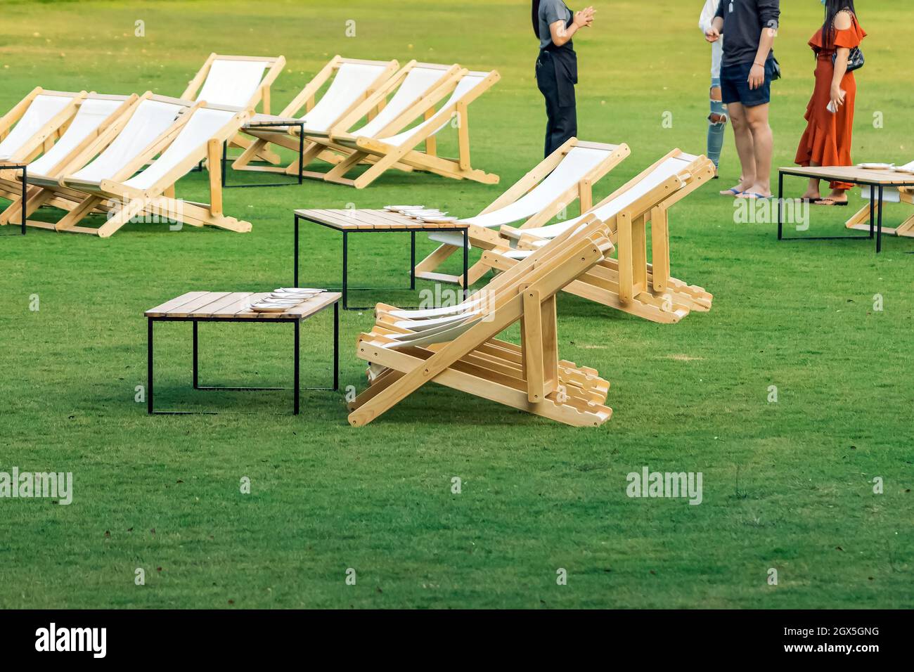 Many empty white deck chairs with tables for dinner in lawn is ...