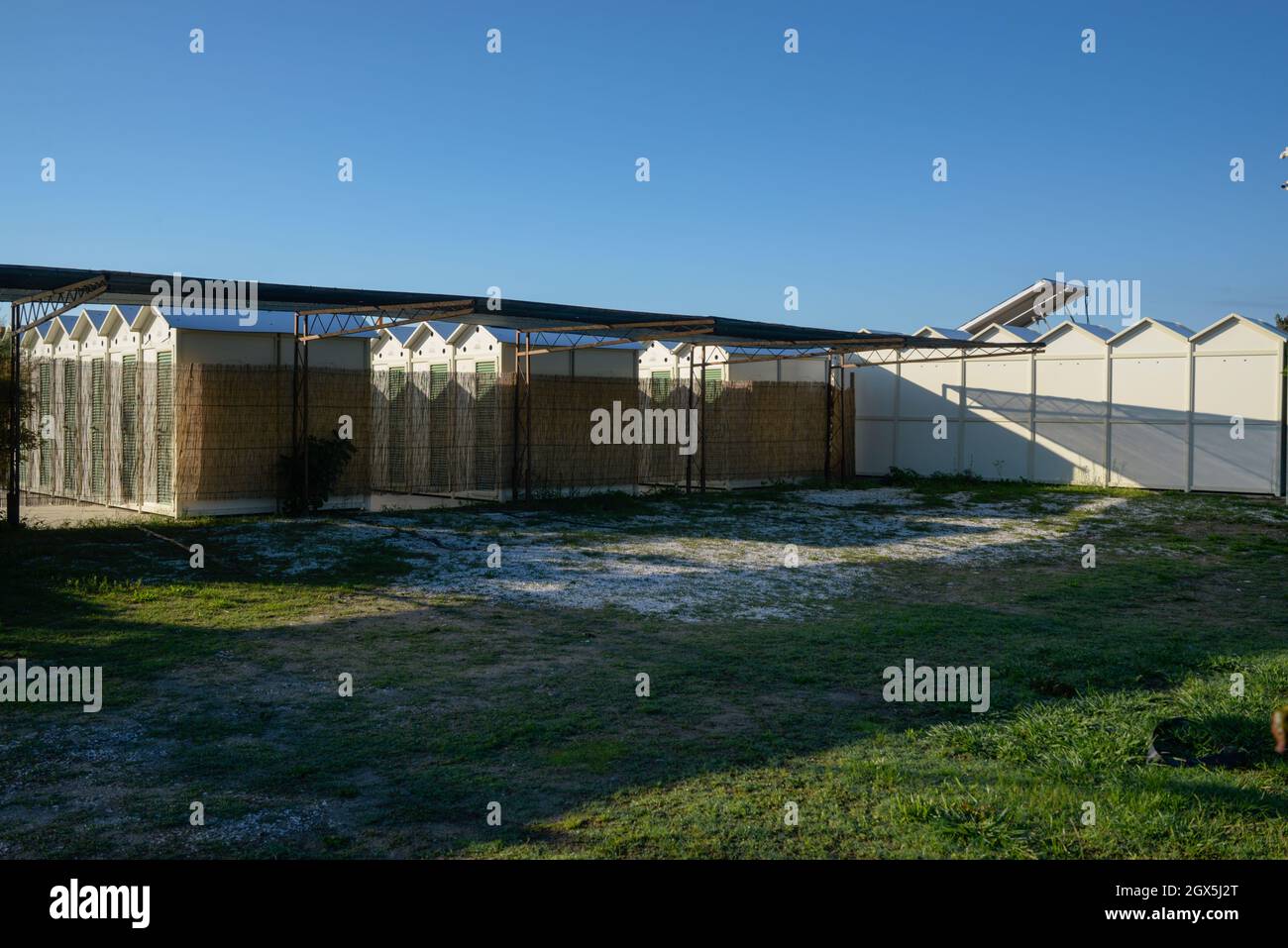 Abandoned white and wooden bathing structures on the sandy beach of ...