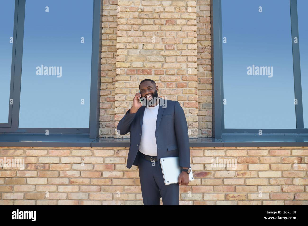 A dark-skinned man talking on the phone and looking interested Stock ...