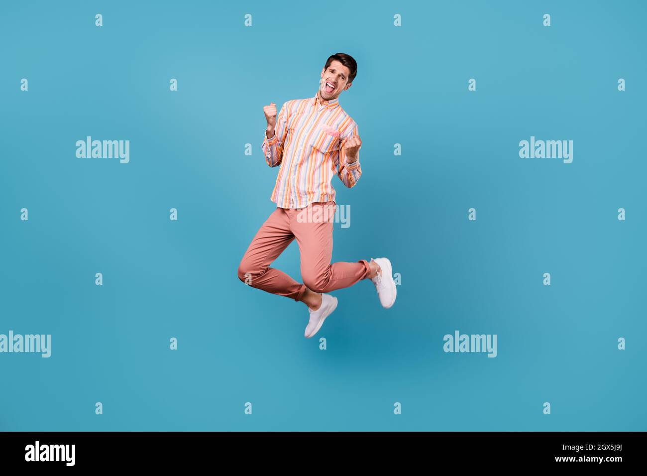 Full size photo of young man jump happy positive smile rejoice victory ...