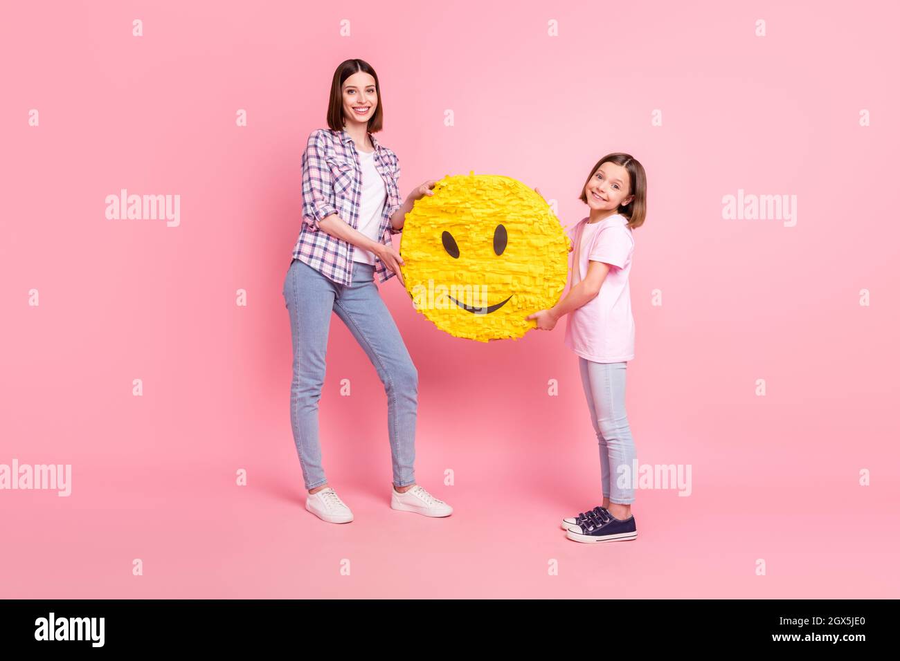 Full length body size view of pretty cheerful sisters holding yellow ...