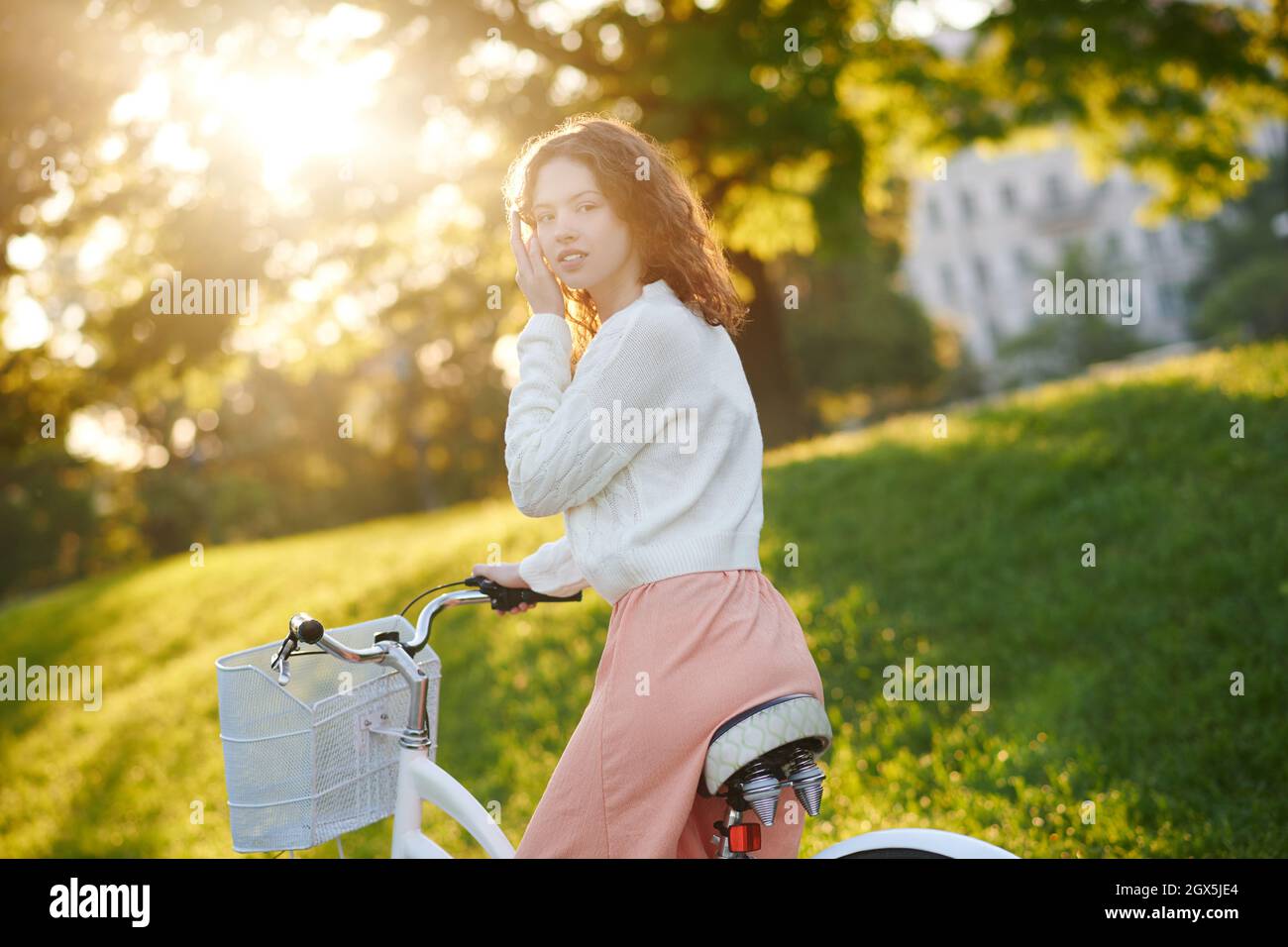 A young girl riding a bike in sunlight in the park Stock Photo - Alamy