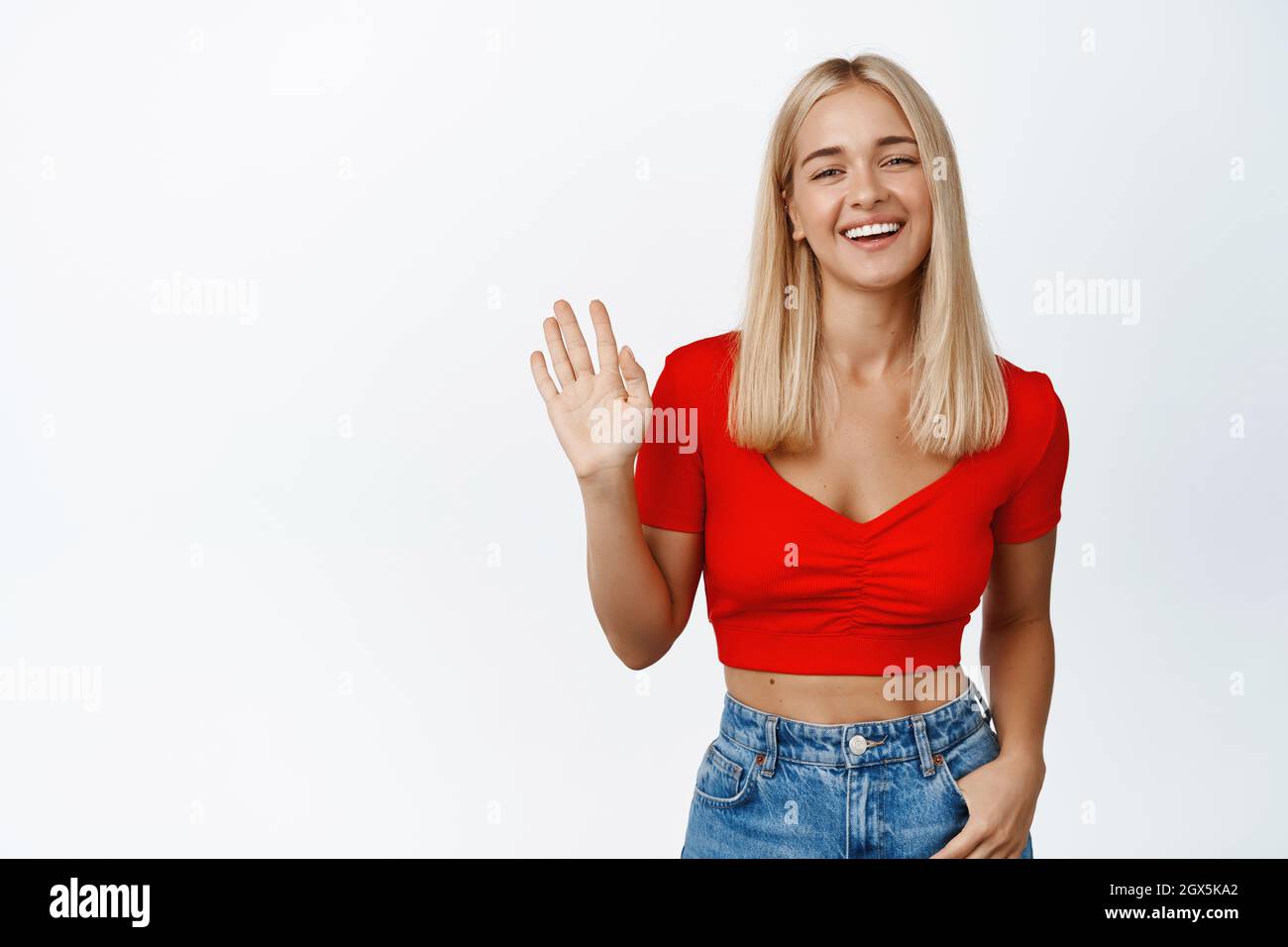 Friendly stylish woman saying hello, waving hand to greet you and ...