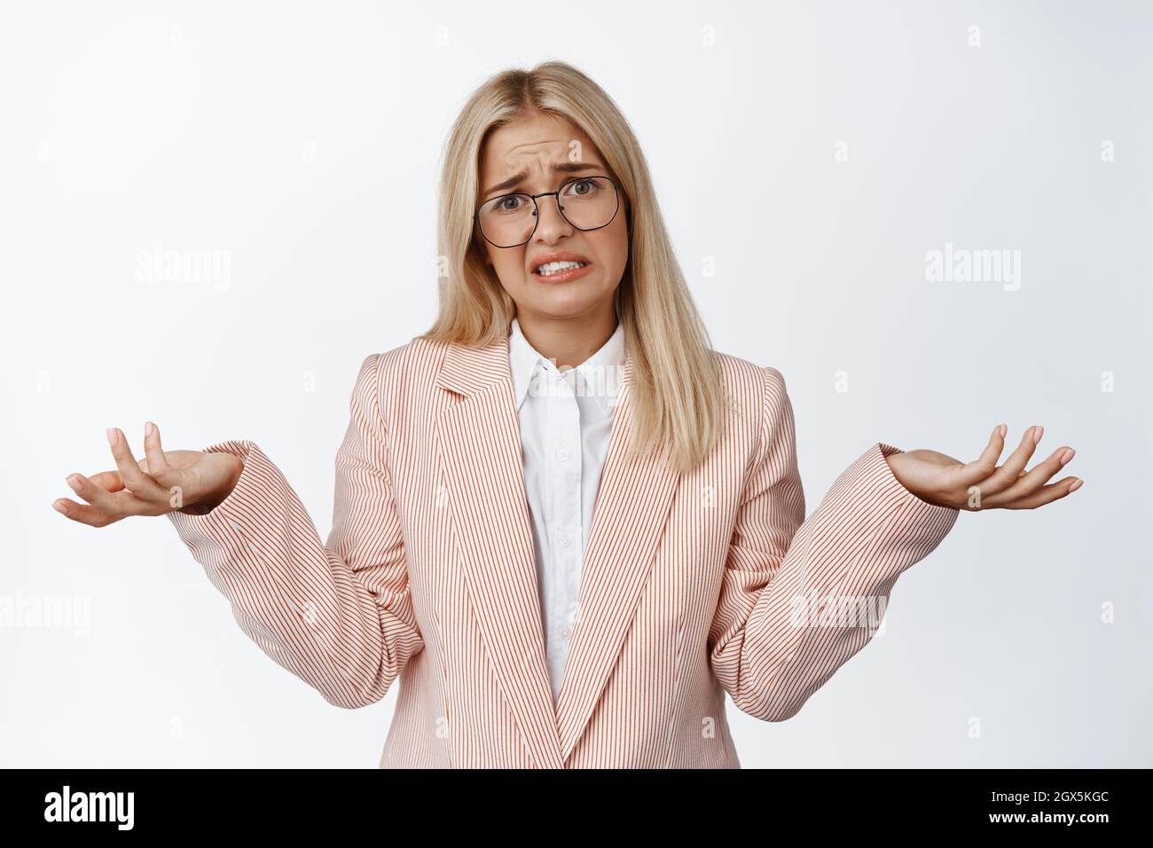 Image of young business woman apologizing, shrugging shoulders and ...