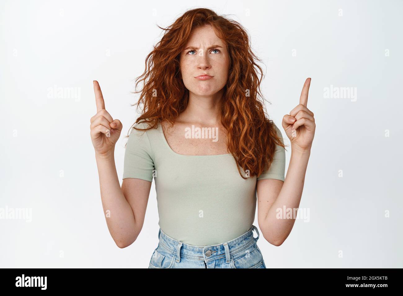 Image Of Redhead Girl Sulking Pointing Fingers Up And Looking Upset